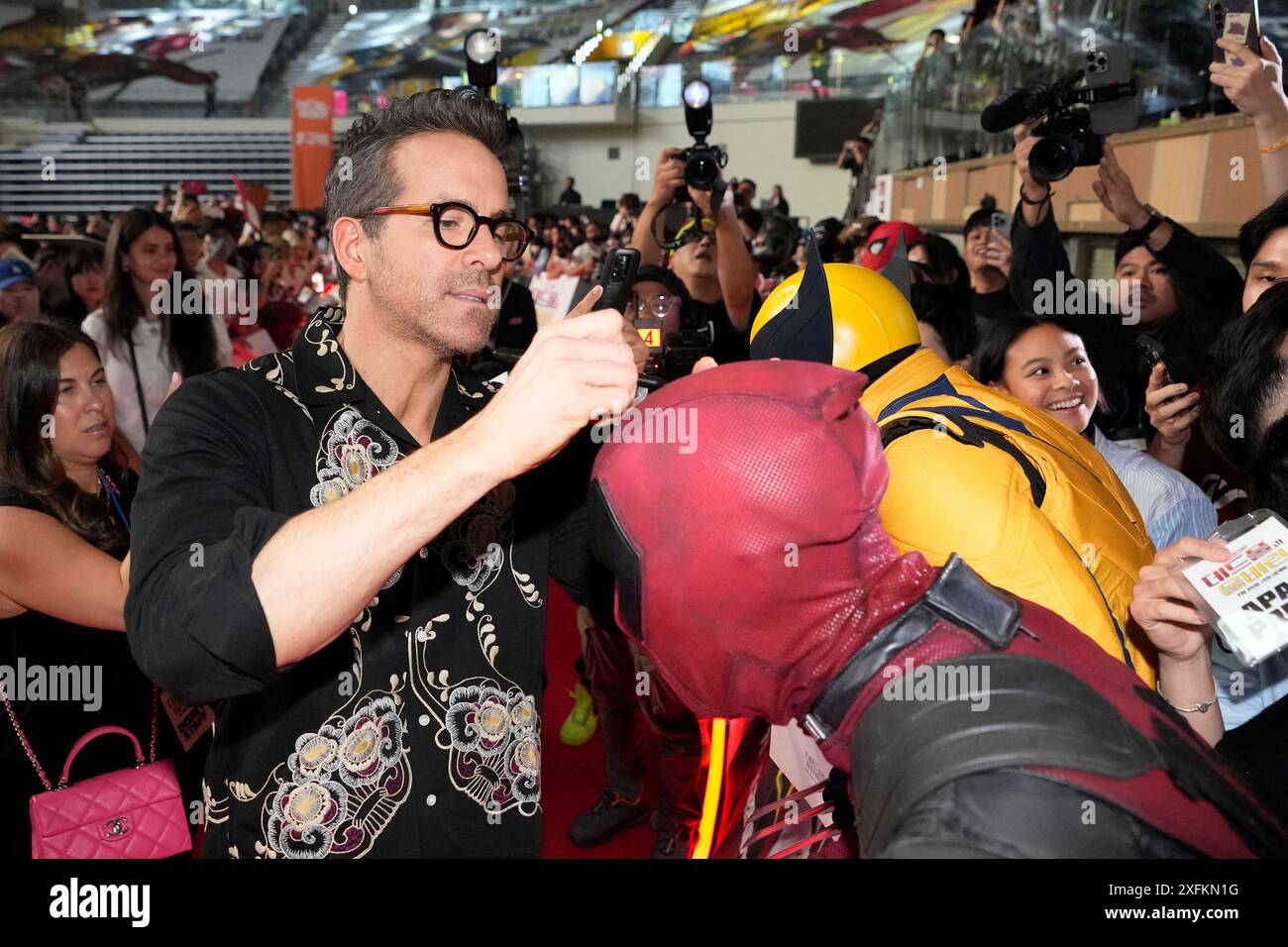 Actor Ryan Reynolds signs an autograph for fans during the red carpet ...