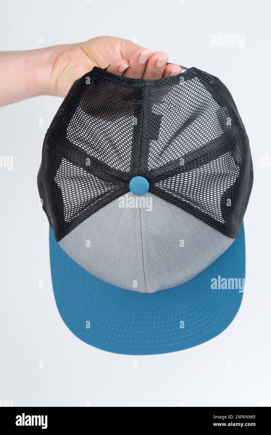 Blue baseball hat in hand hang isolated on white studio background ...