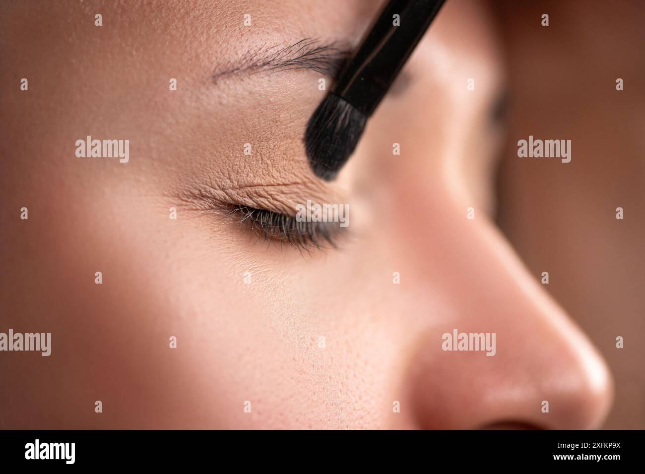 Make-up detail. Makeup Artist applies Eye Shadow on female eyes ...