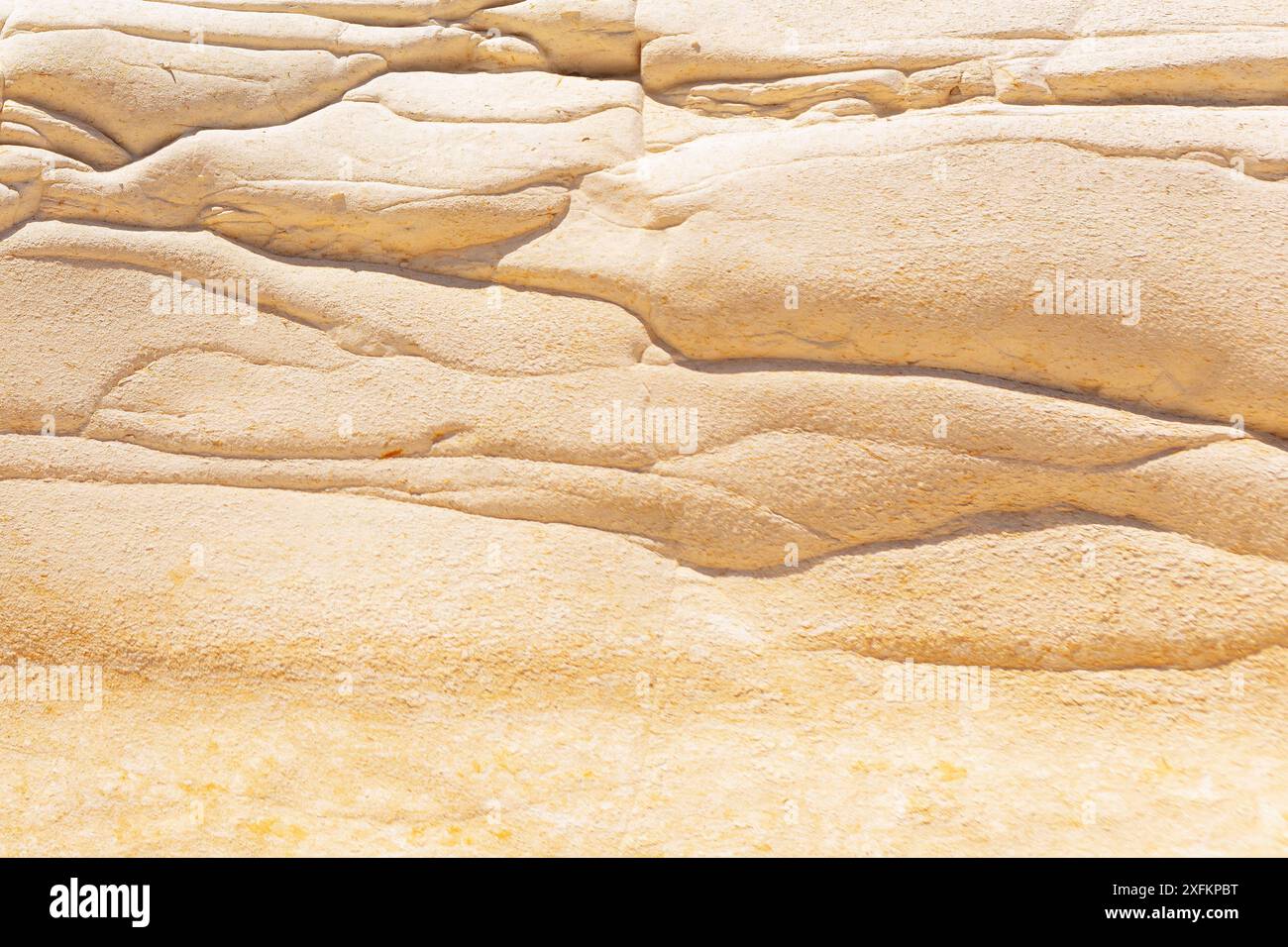 Background of a rocky cliff with a sandy beach below. The texture of ...