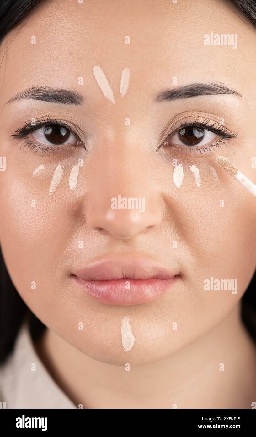 Foundation or concealer on japanese girl face. Cosmetic concealer based ...