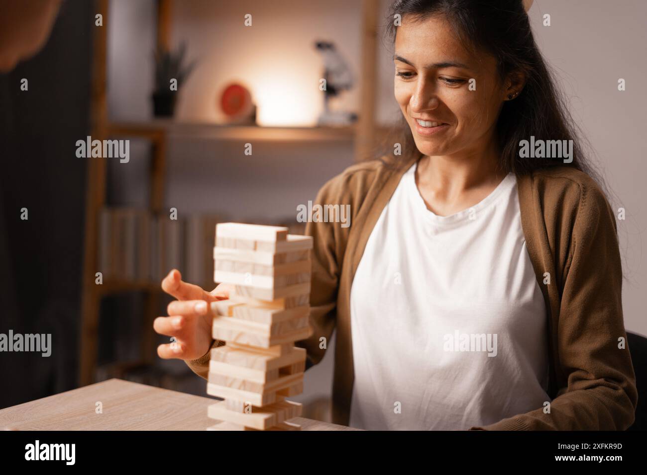 Smiling Woman Removing Wooden Block from Tower During Board Game at ...