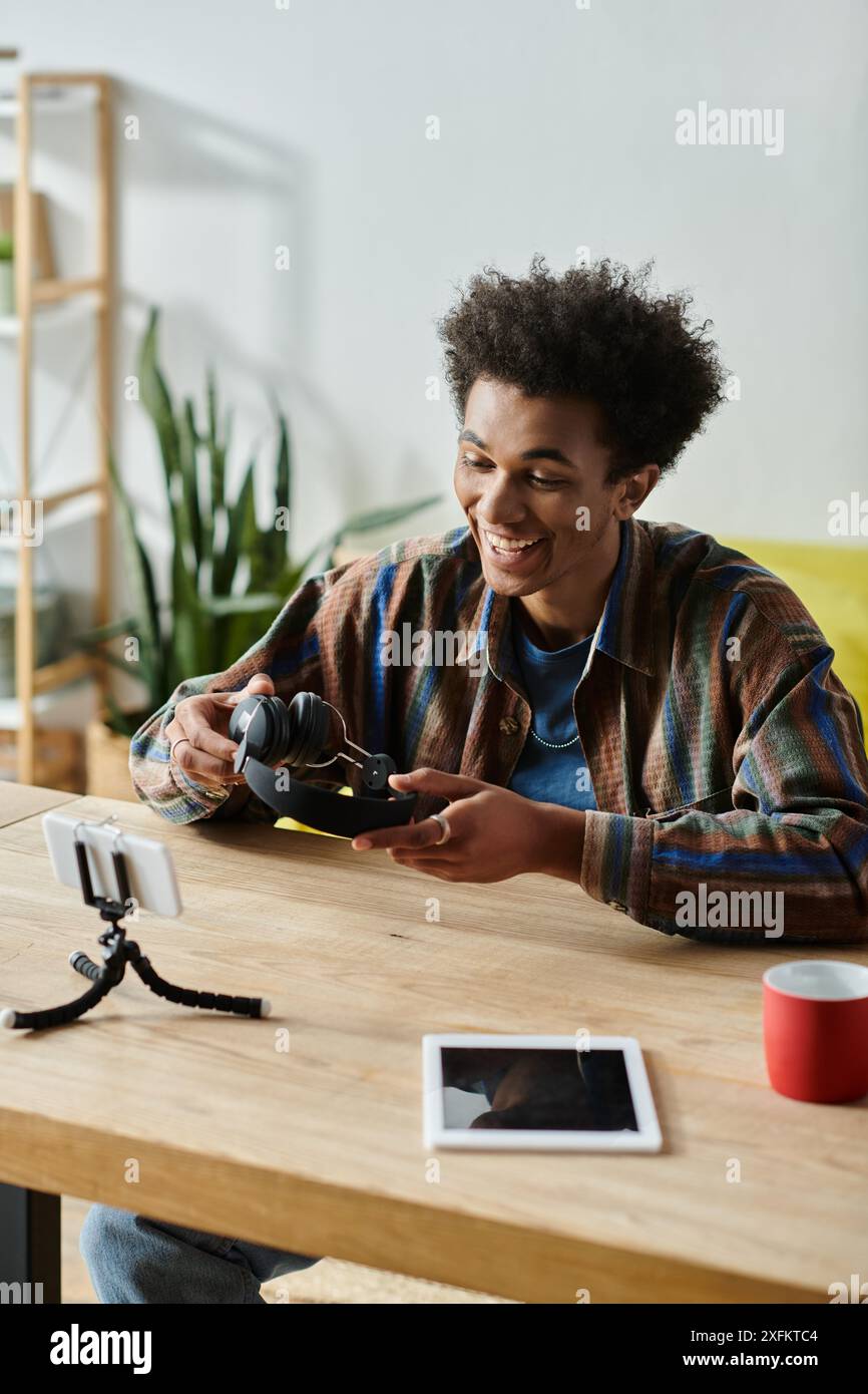 A young African American man busy with his tablet and phone ...