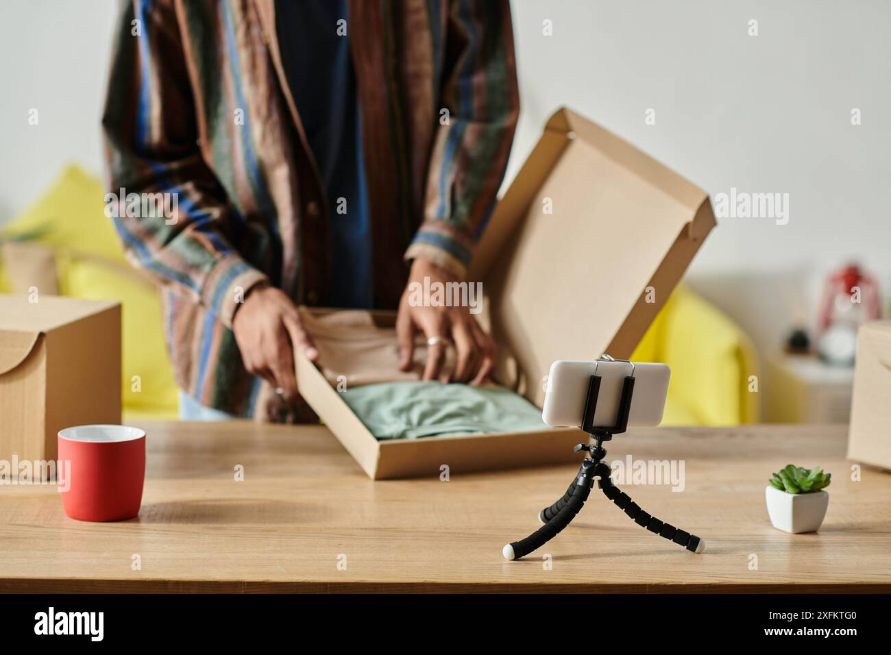 A man revealing the contents of a box while sitting at a table Stock ...