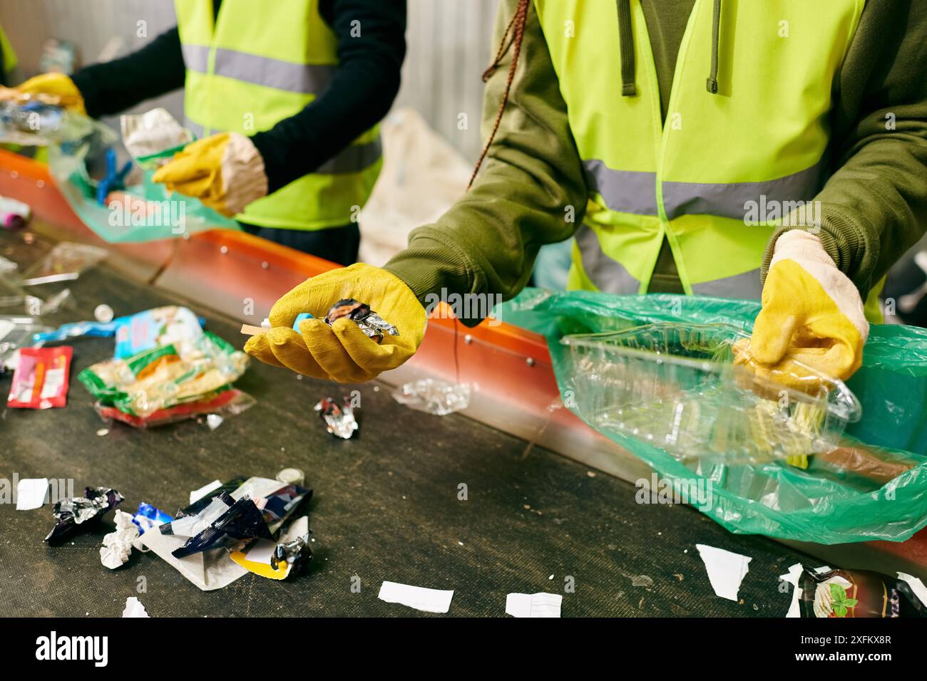 Group of eco-conscious young volunteers in yellow safety vests cleaning ...