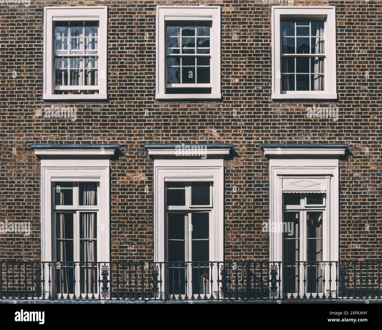 Three White Windows With Black Railings on Brick Building in London ...