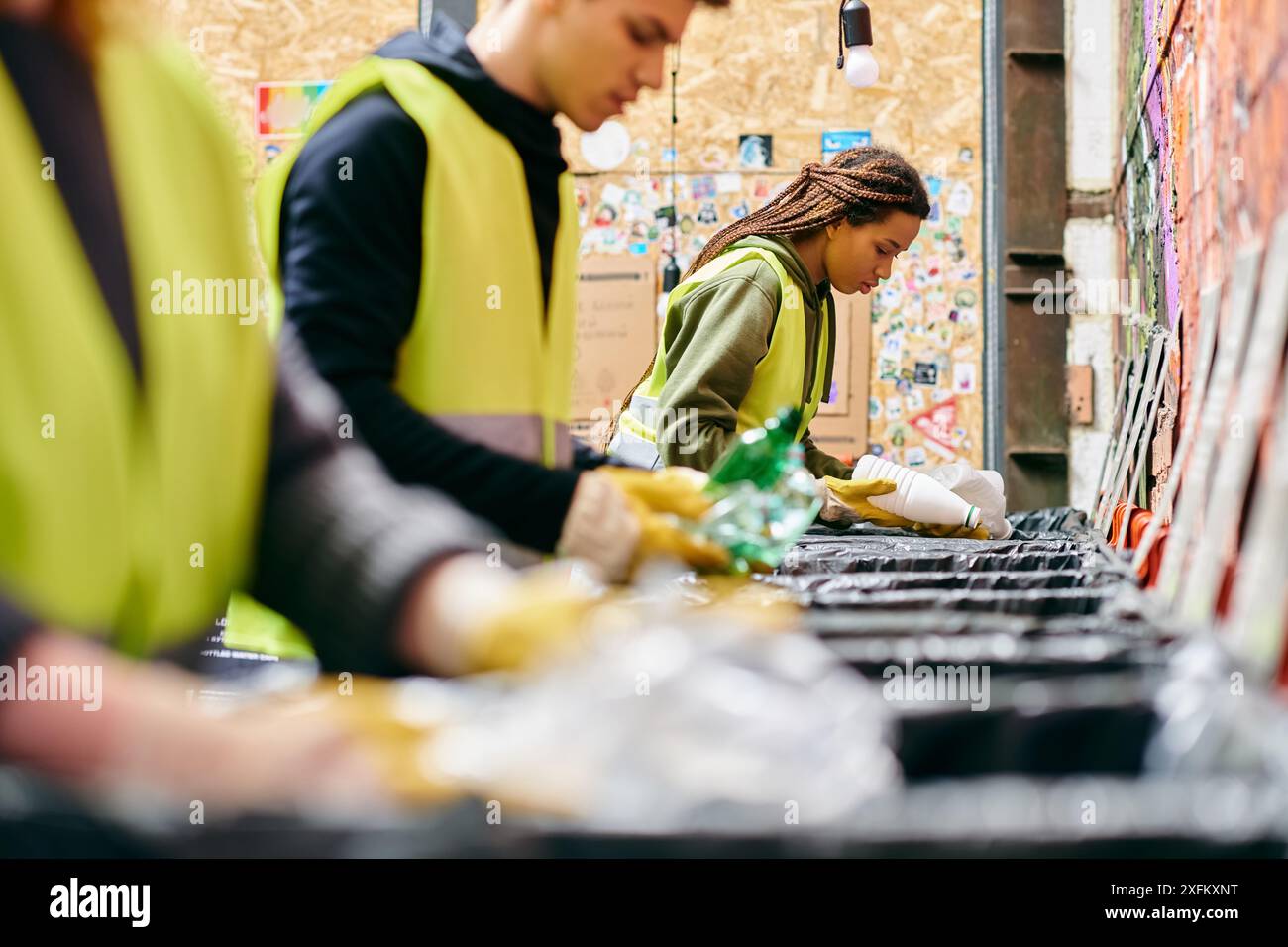 Group of young volunteers in gloves and safety vests engaging in eco ...