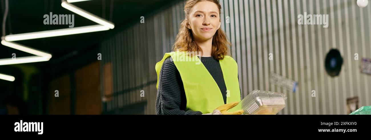 A young volunteer in gloves and safety vest, sorting food waste with ...