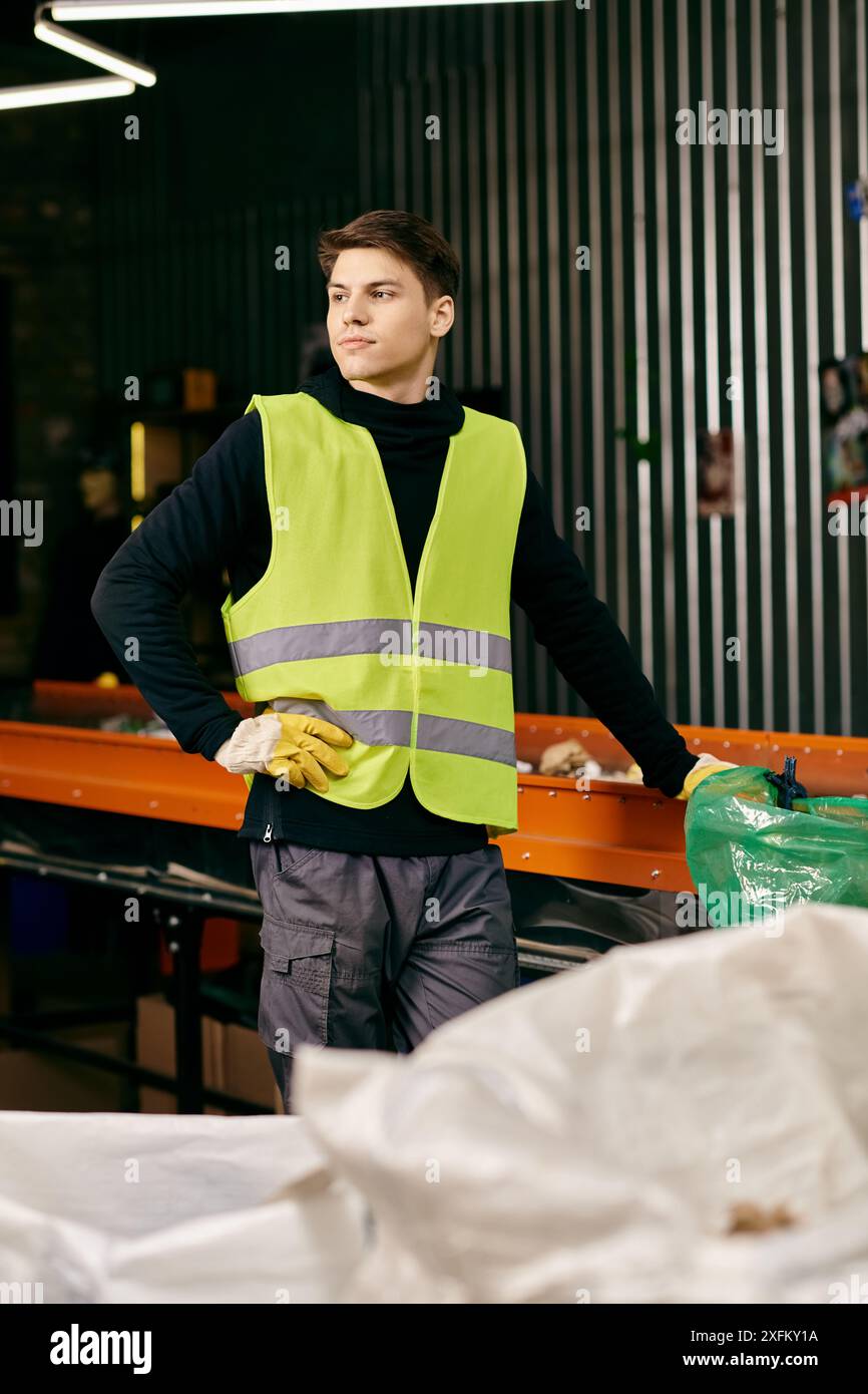 A young volunteer in gloves and safety vest sorting waste in a ...