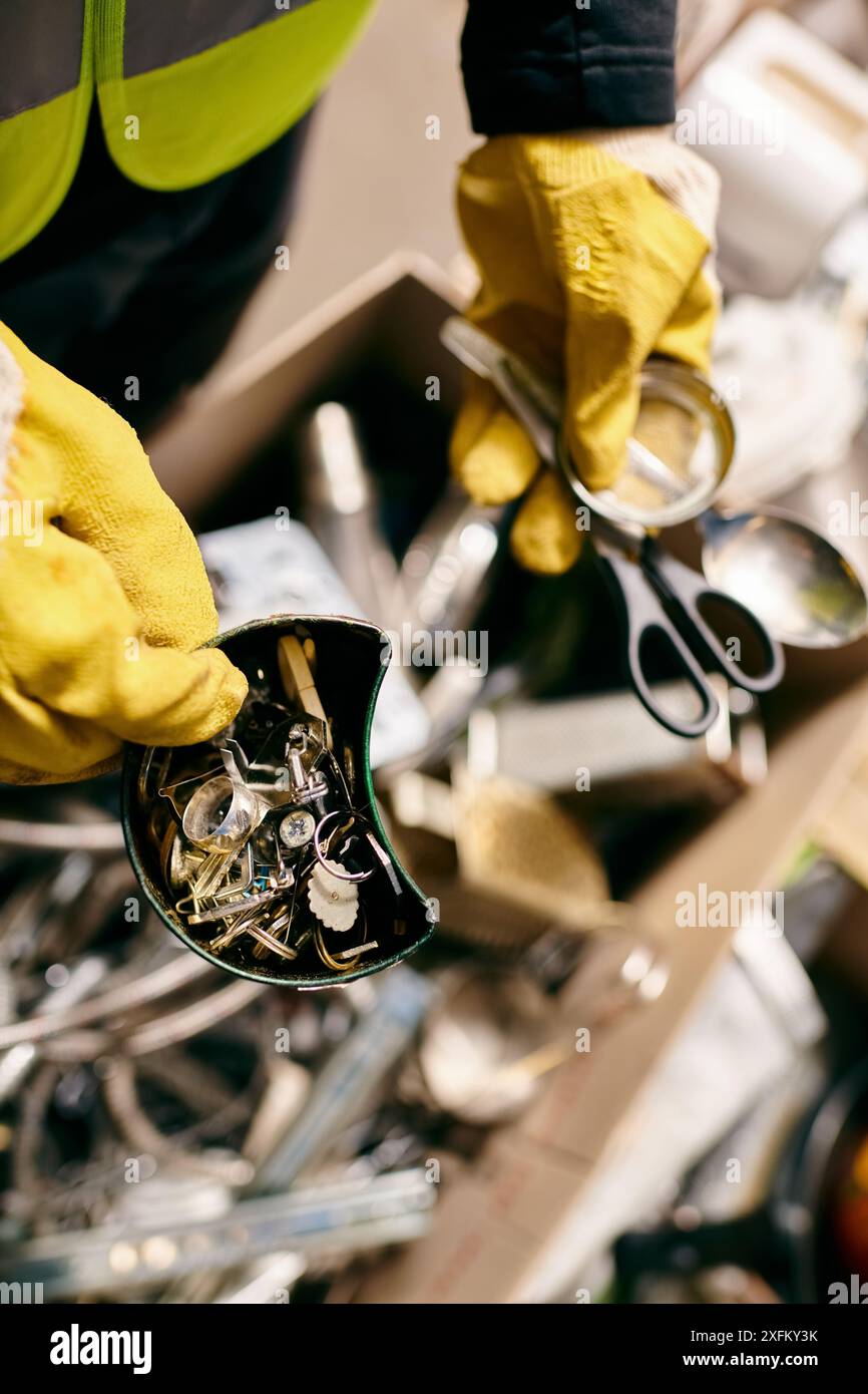 A young volunteer in yellow gloves cuts with scissors while sorting ...
