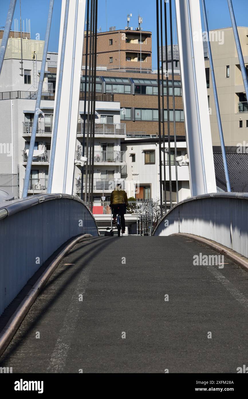 A man on a bicycle crossing the Kawasakibashi bridge across the O river ...