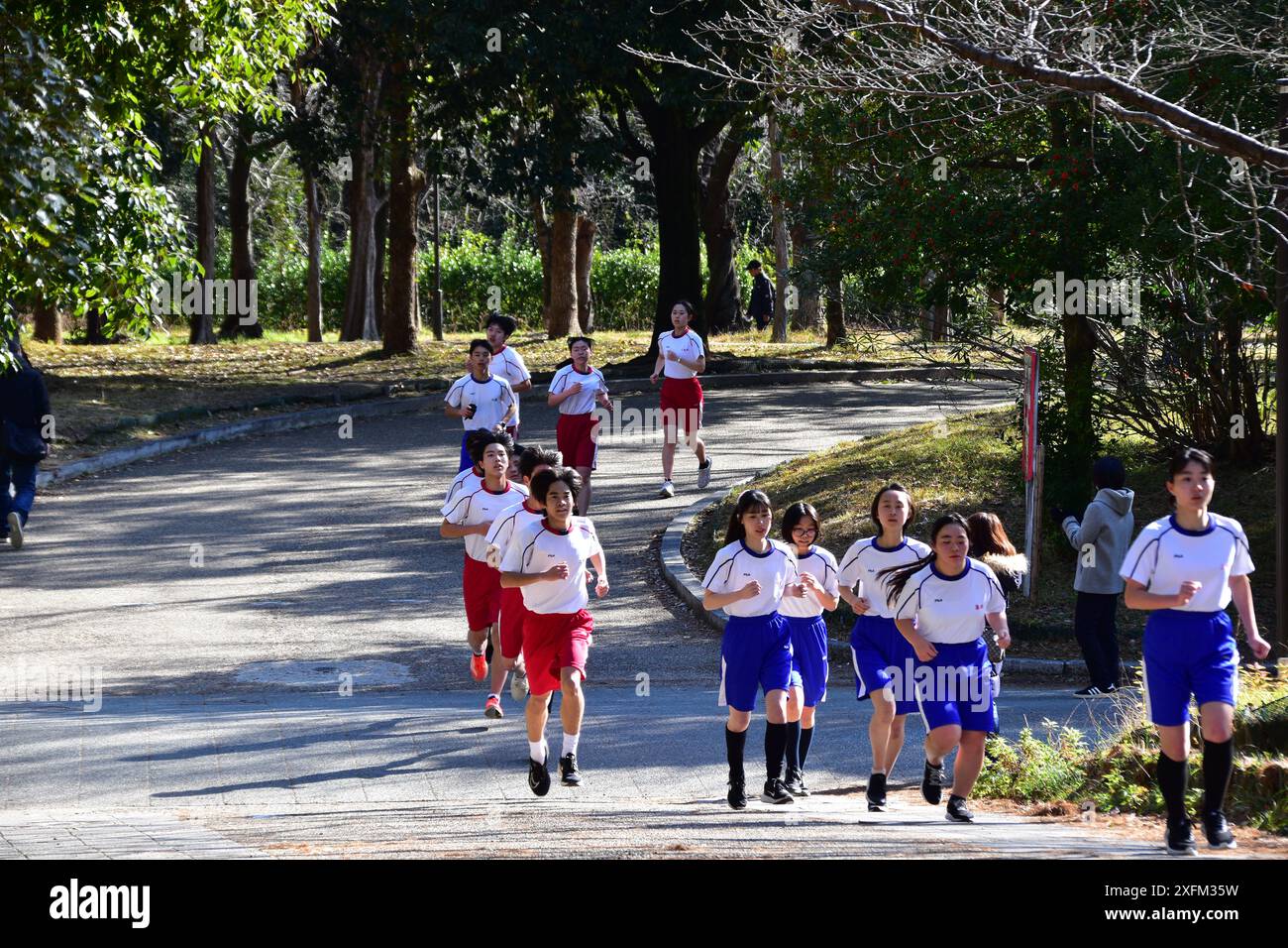 Japanese high school students in gym outfit jogging in Osaka Castle ...