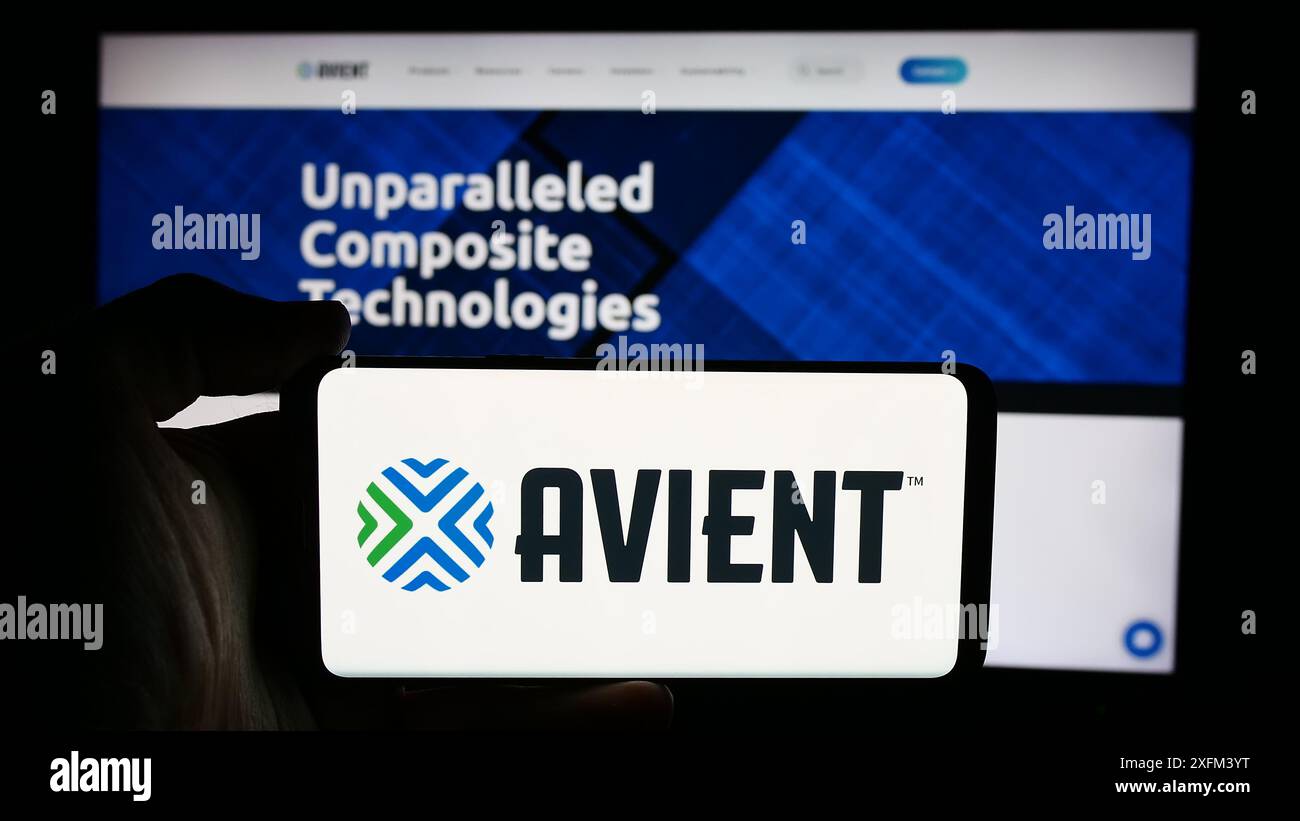 Person holding cellphone with logo of US polymer materials company Avient Corporation in front ...