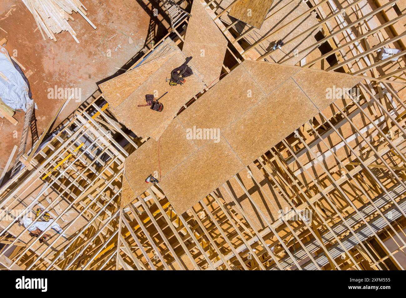 An installation of timber trusses framed by a house under construction ...