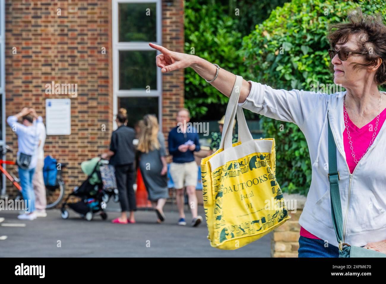 London, UK. 4th July, 2024. Pointing the way - Large queues, including ...