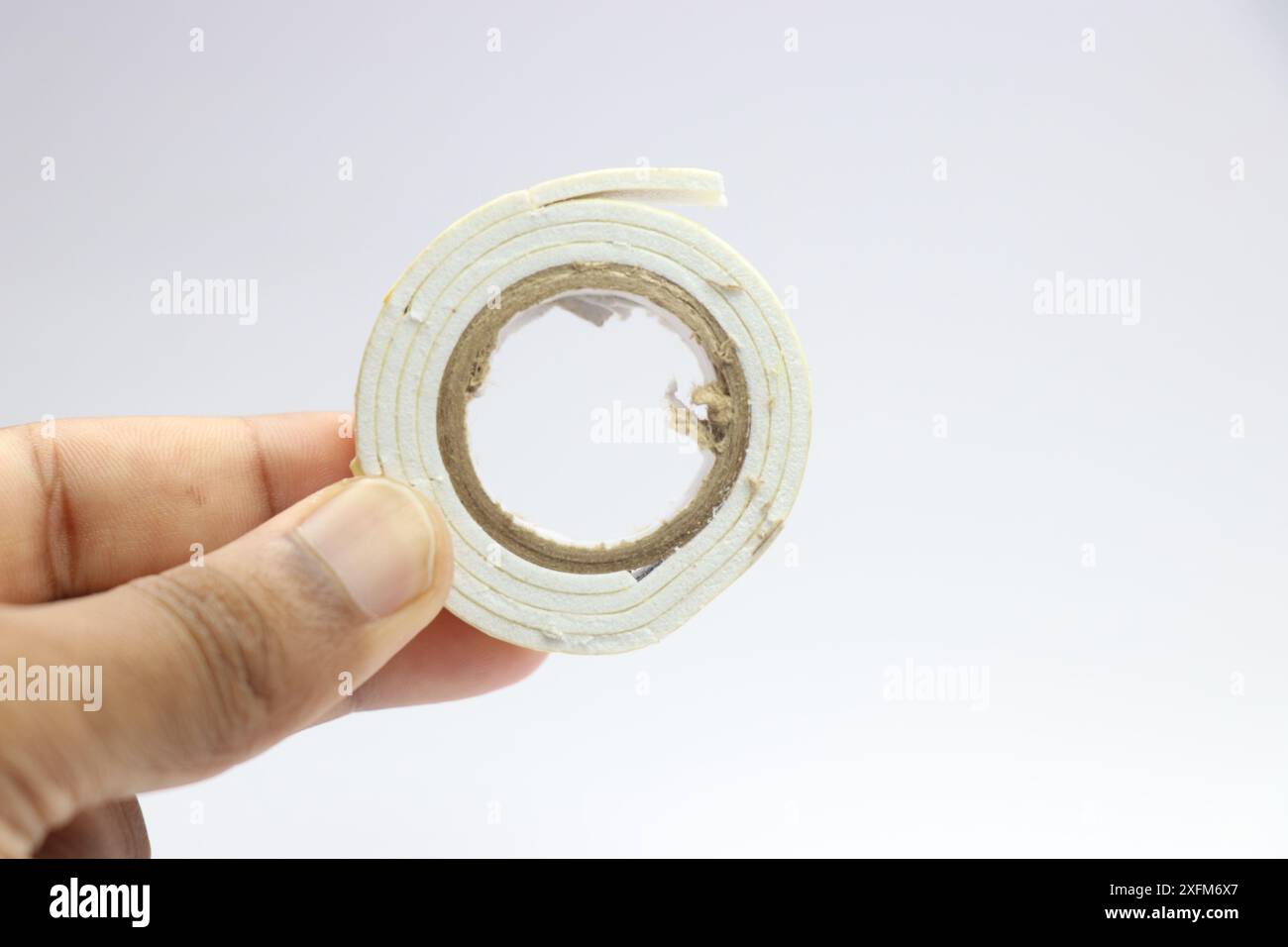 Double sided adhesive tape used to join two objects held in the hand ...