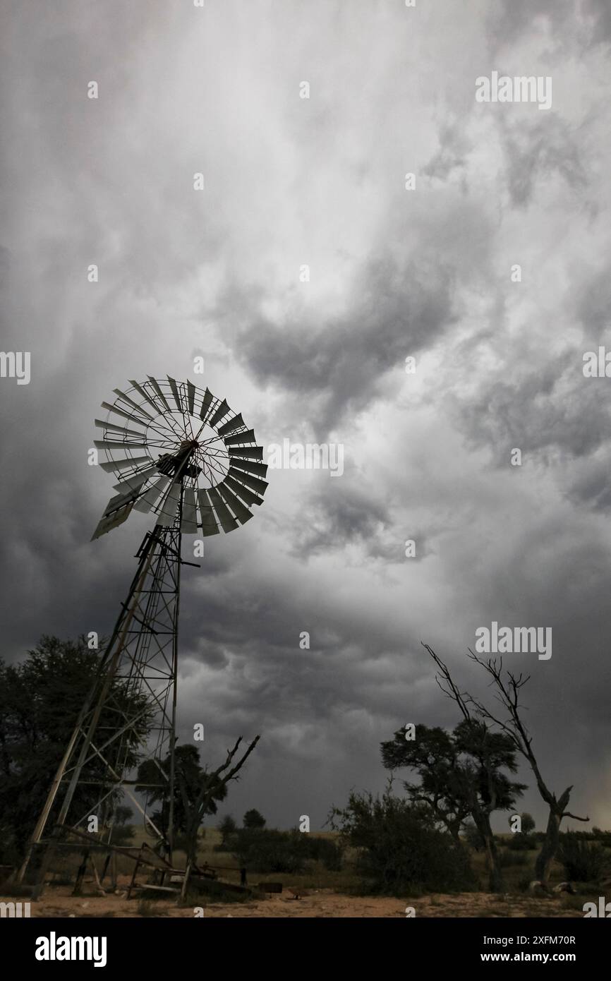 Windmill under a gathering thunderstorm in the Kalahari Desert, South ...