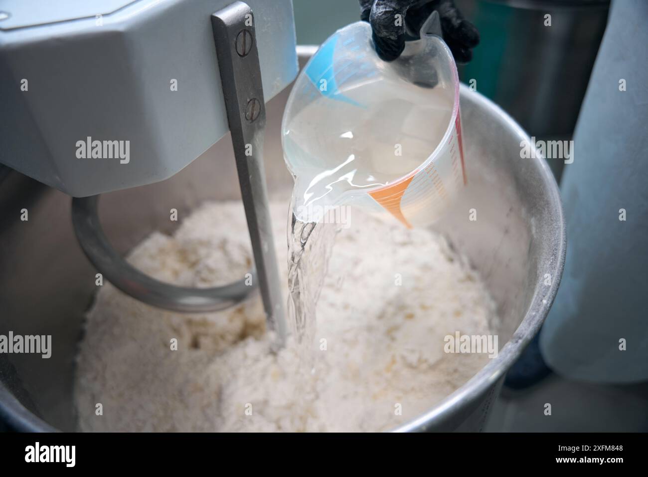 Chef pours water into a dough kneading machine Stock Photo - Alamy