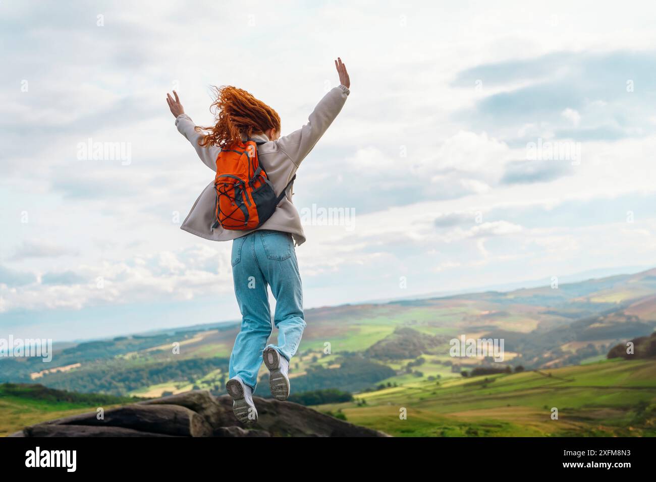 amazing redhead woman with orange backpack raising her hands, jumping ...