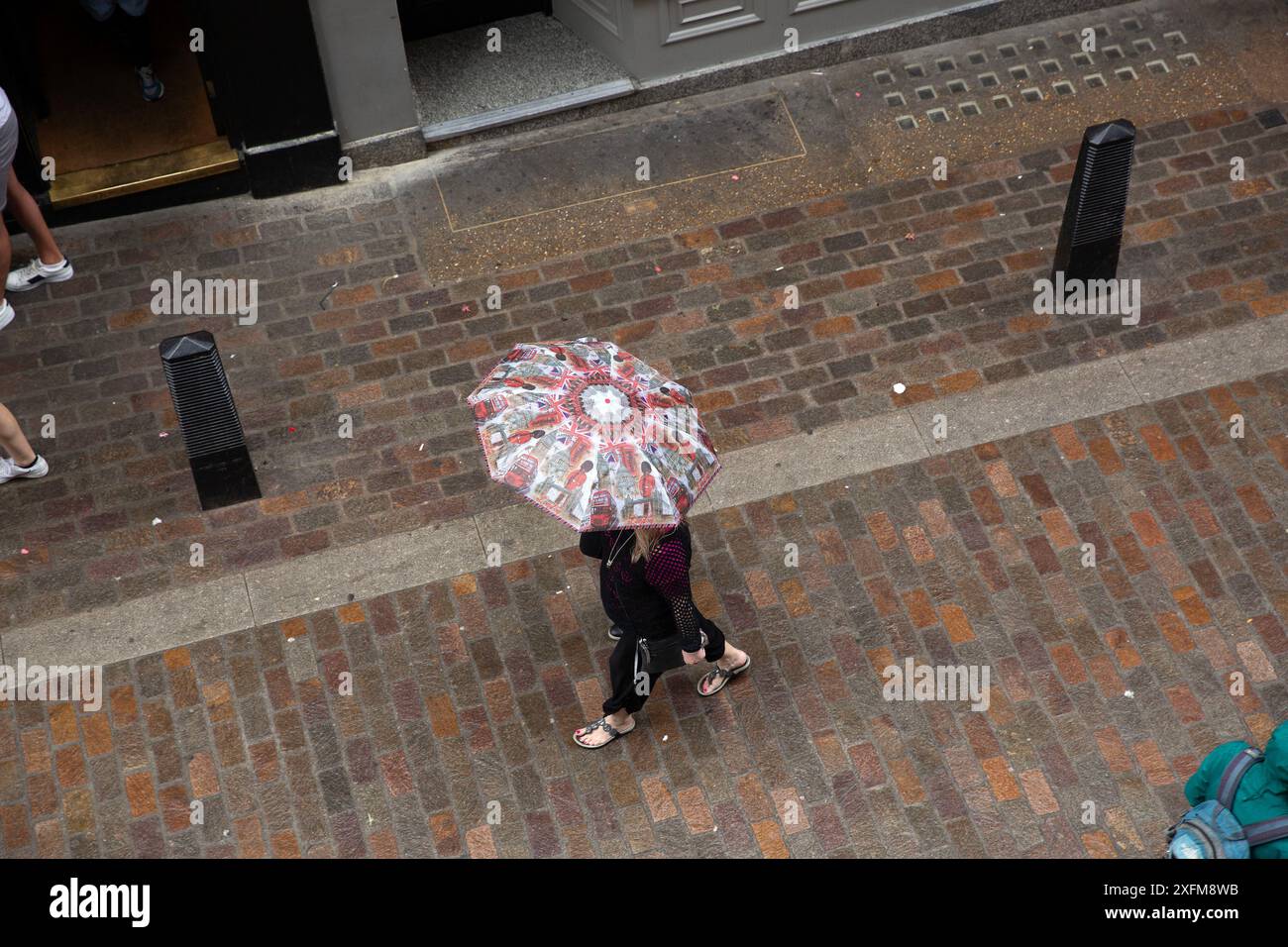 Pedestrians sheltering under their umbrella walk in London Stock Photo ...