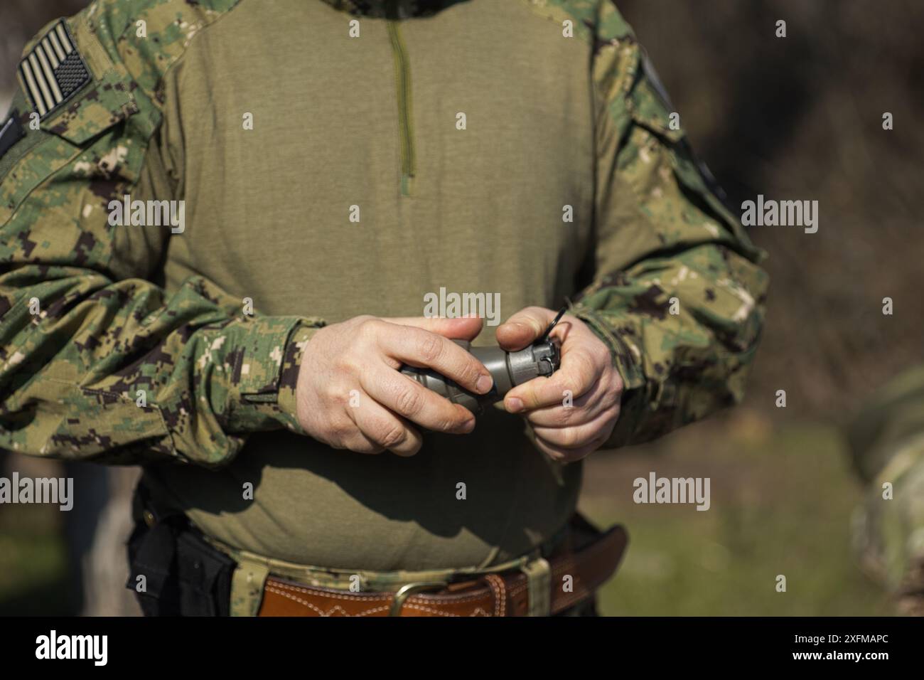 an airsoft grenade in the hands of a man in an American uniform Stock ...