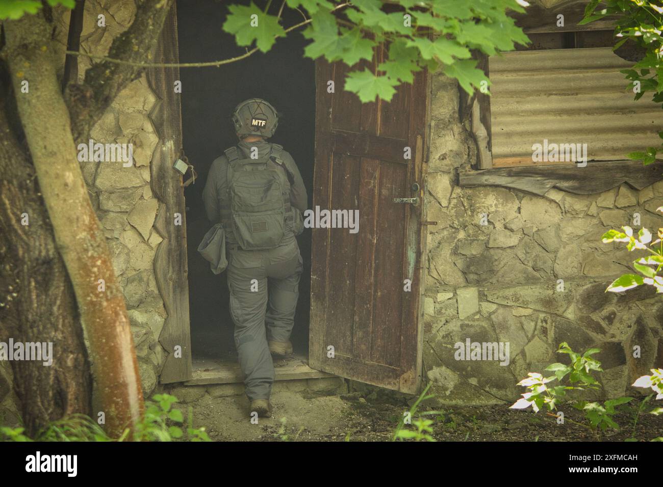 airsoft game on the street near abandoned buildings, a man in a gray ...