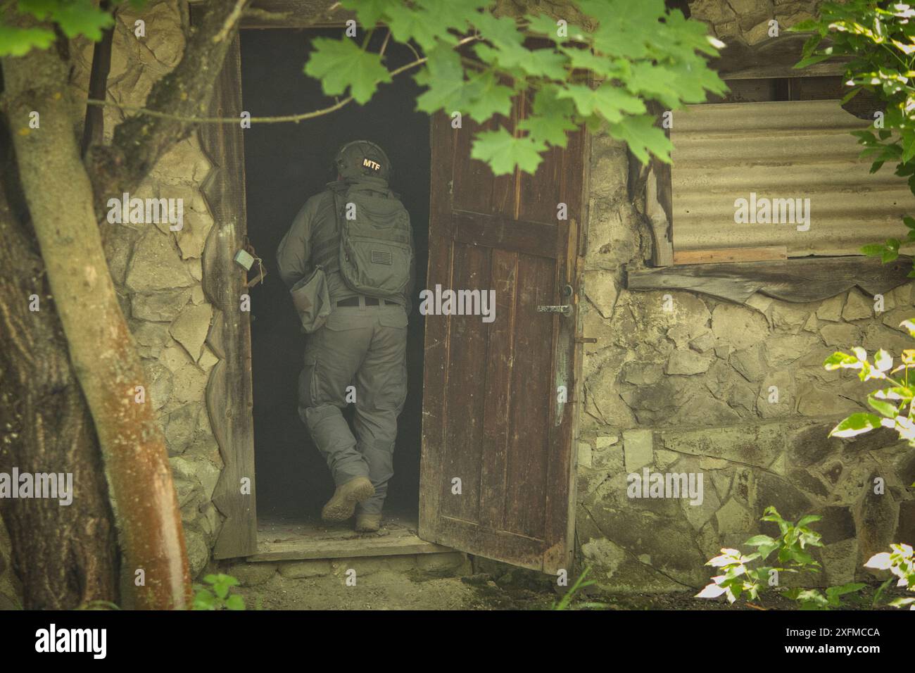 airsoft game on the street near abandoned buildings, a man in a gray ...