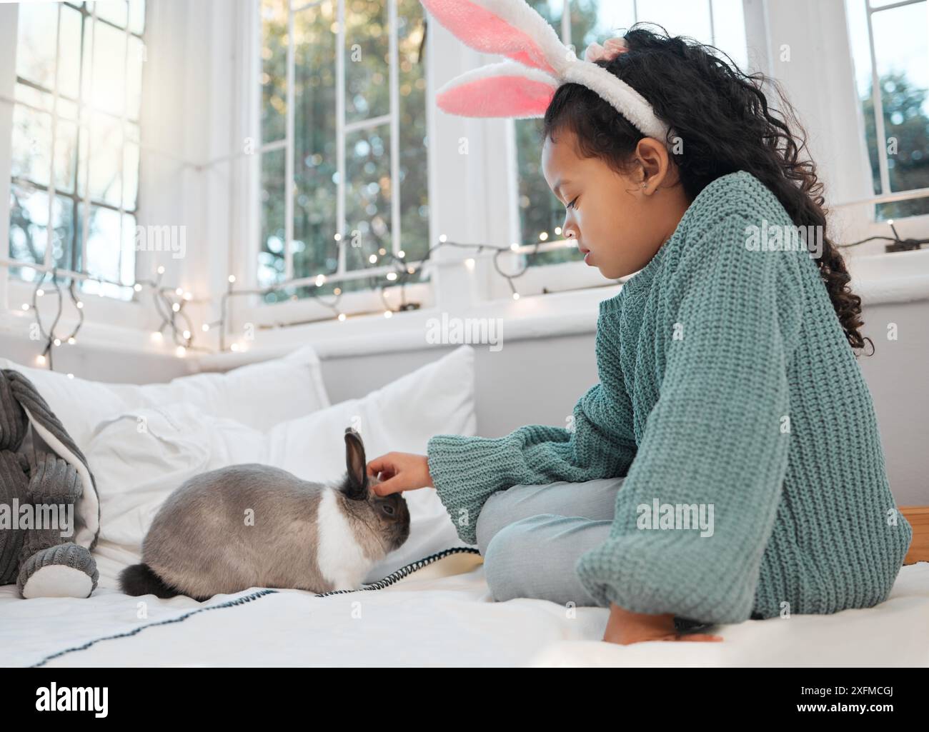 Girl, kid and stroke rabbit in home for love and emotional support, pet ...