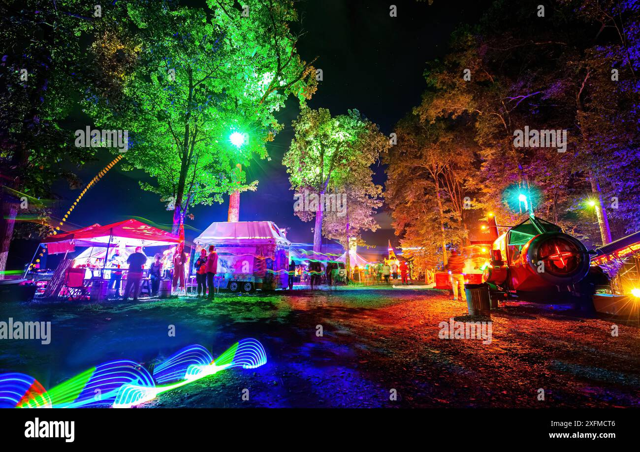 Colorful night campsite festival with illuminated trees and trays of ...
