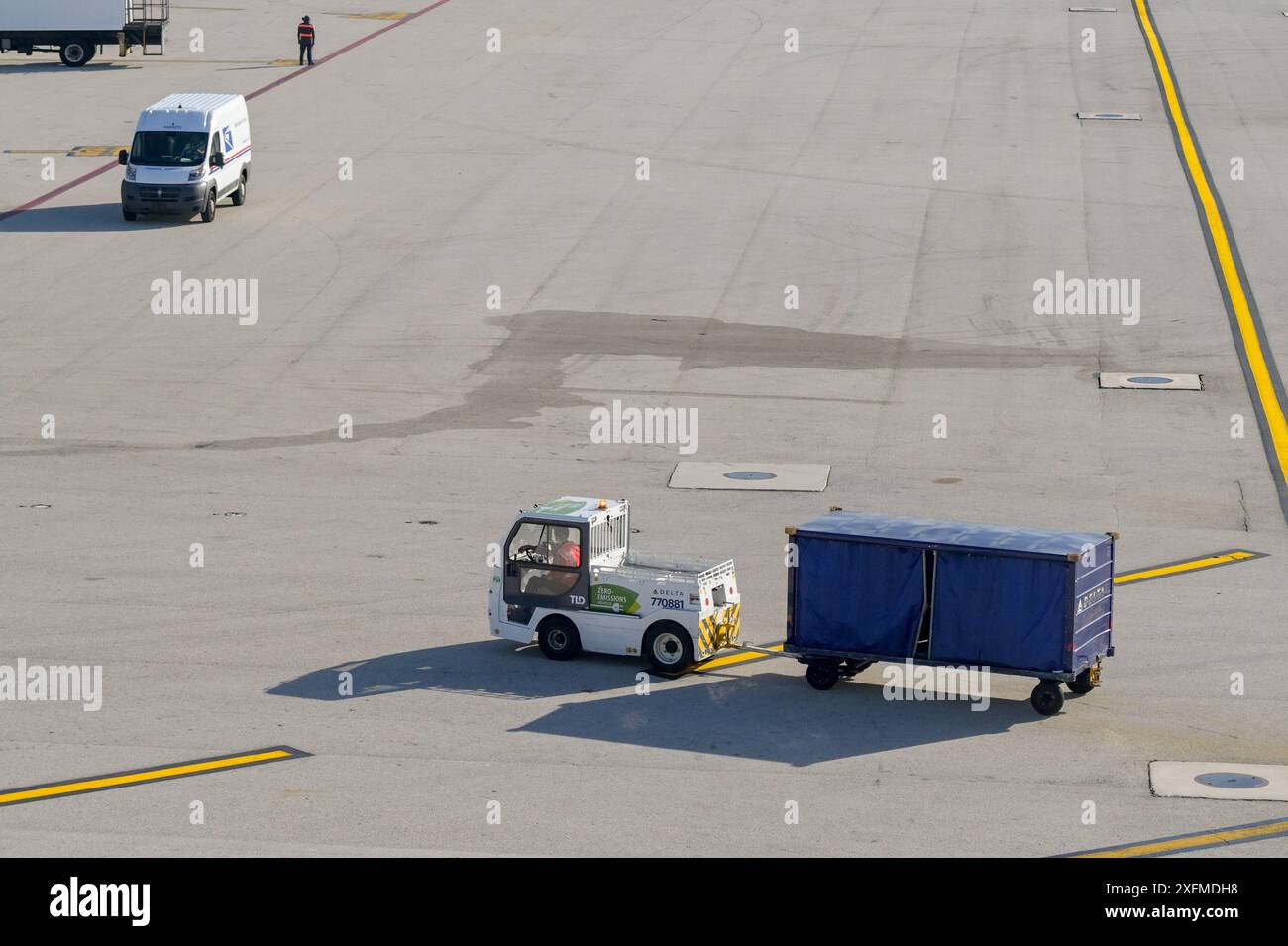 Miami, Florida, USA - % December 2023: Small tractor towing a luggage ...