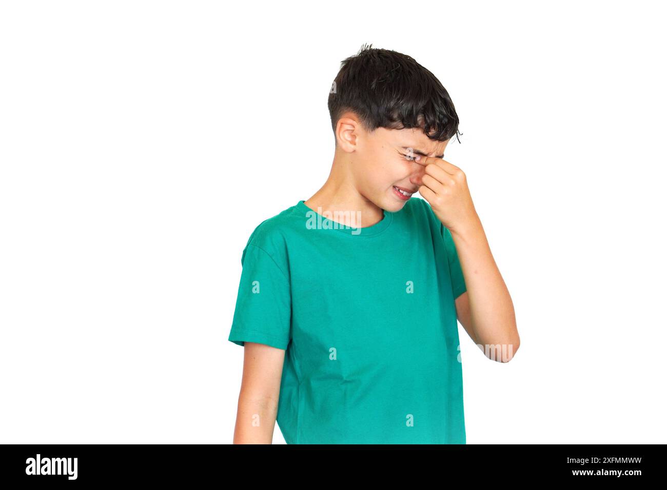 preteen boy with freckles wincing in pain and displeasure by placing ...