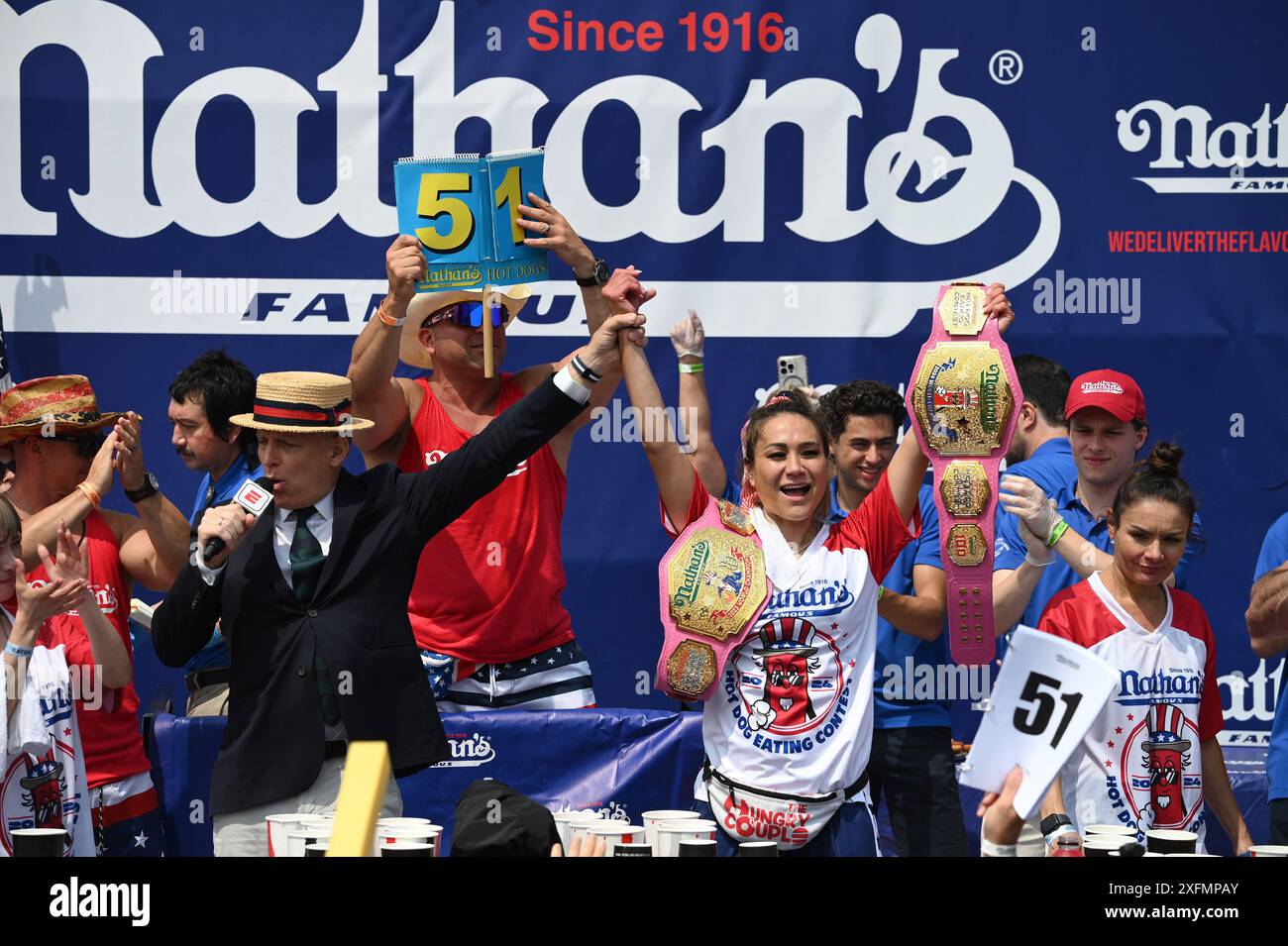 MC George Shea (l) holds Miki Sudo, from Tampa, Florida as she wins the ...