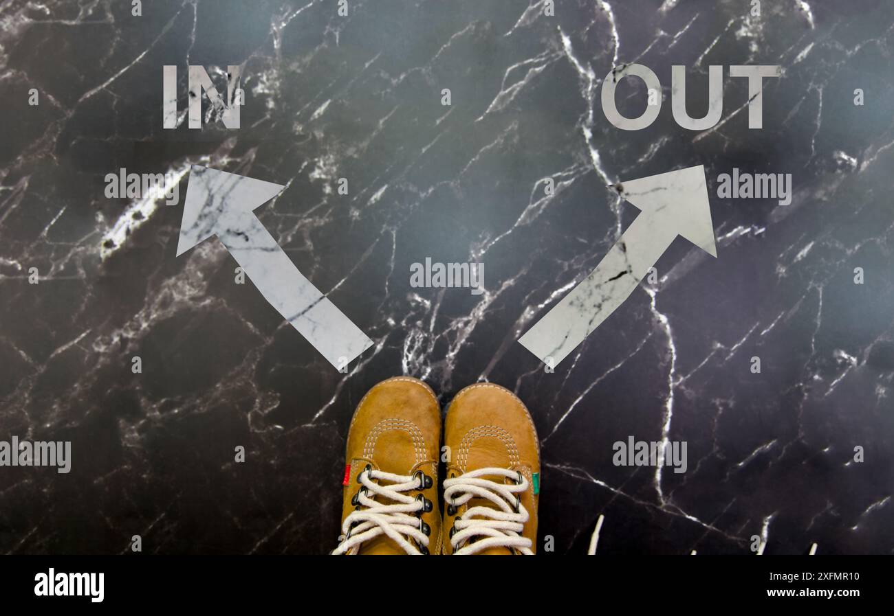 Overhead view of brown boots standing between arrows labeled In and Out ...