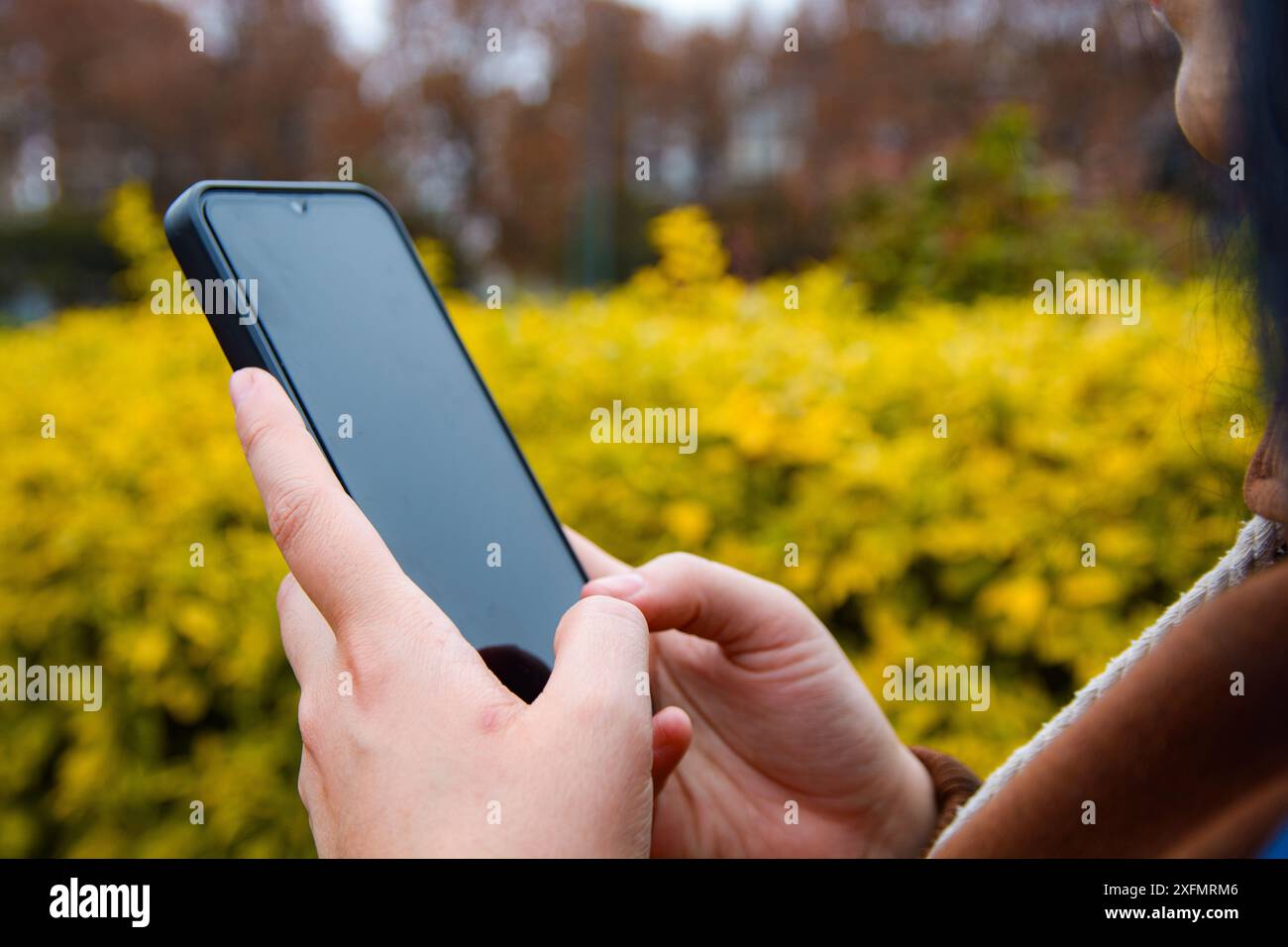 closeup Caucasian female hands using phone with black screen outdoors ...