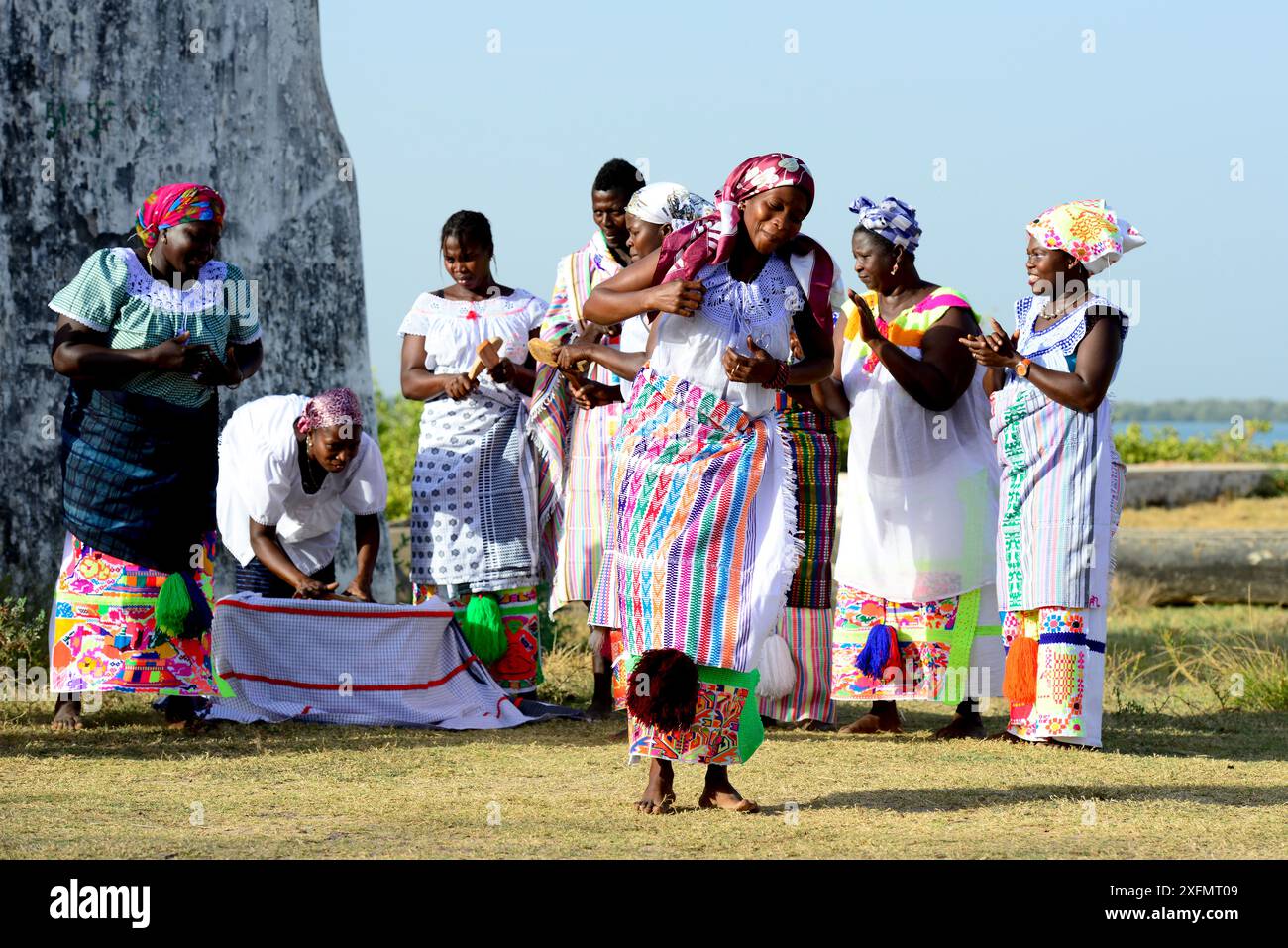 Women dancing with others clapping and playing music for traditional ...