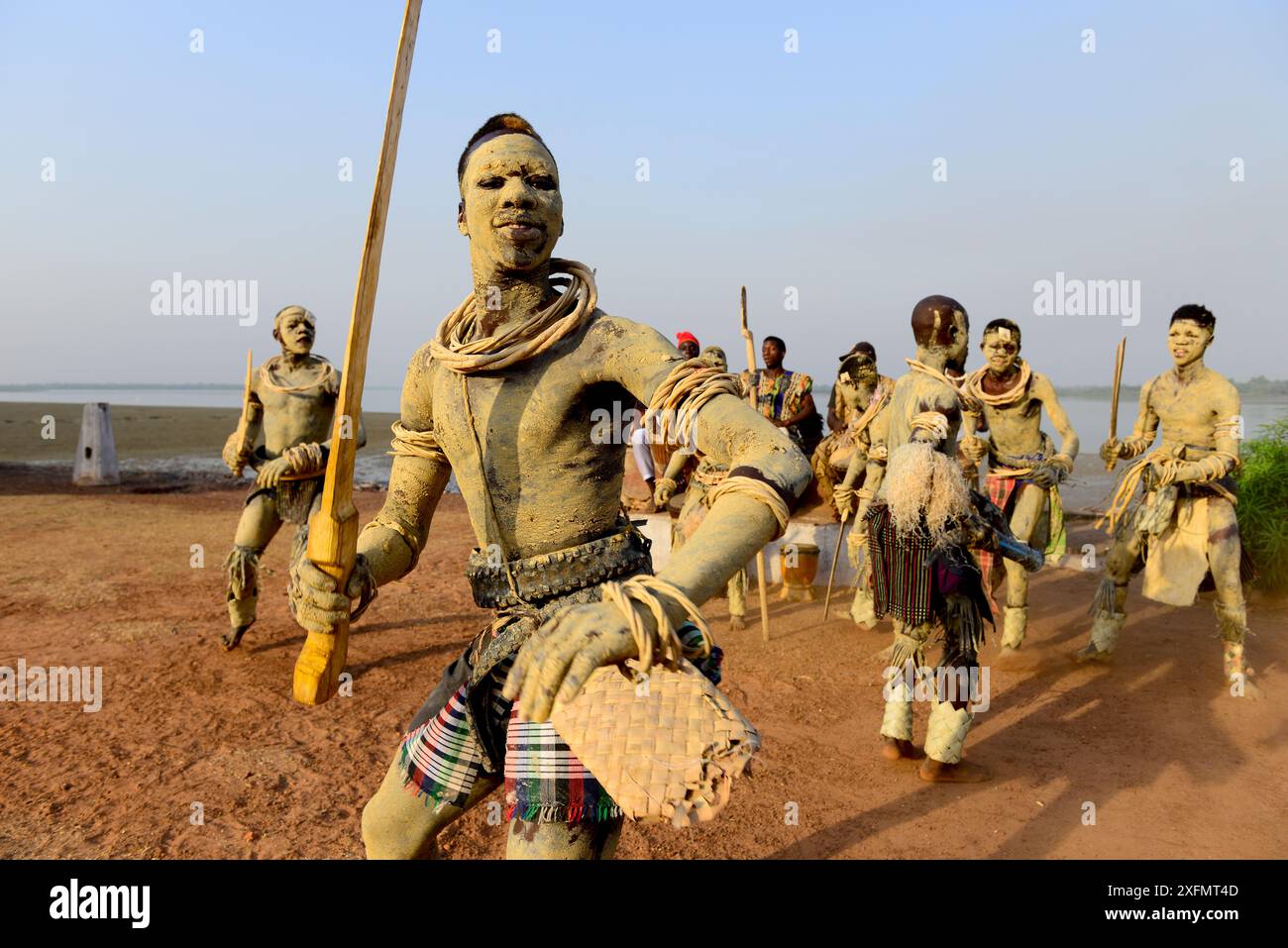 Men with skin coloured with sand participating in traditional dance ...