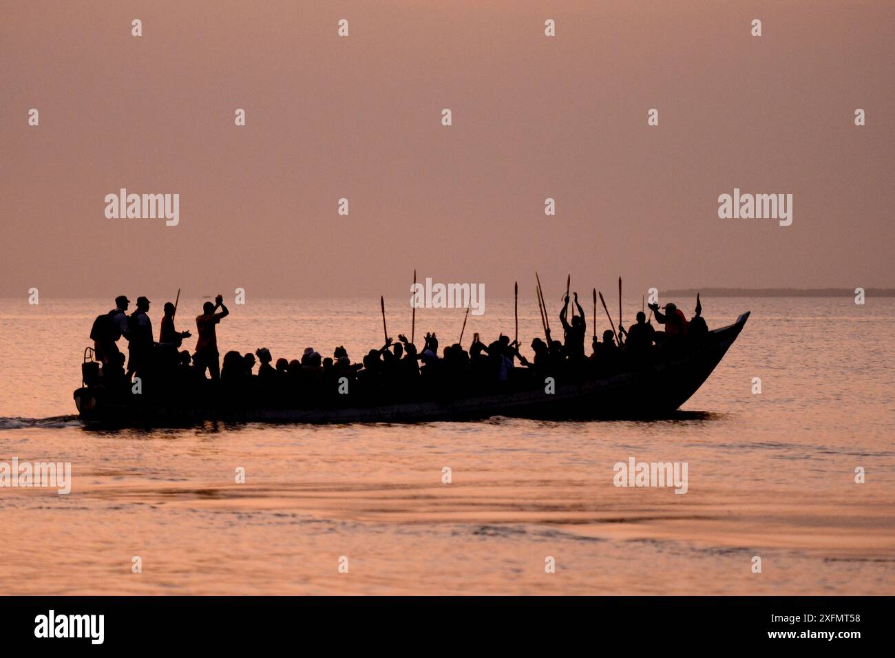 Boat full of carnival participants arriving at sunset, Eticoga Carnival ...