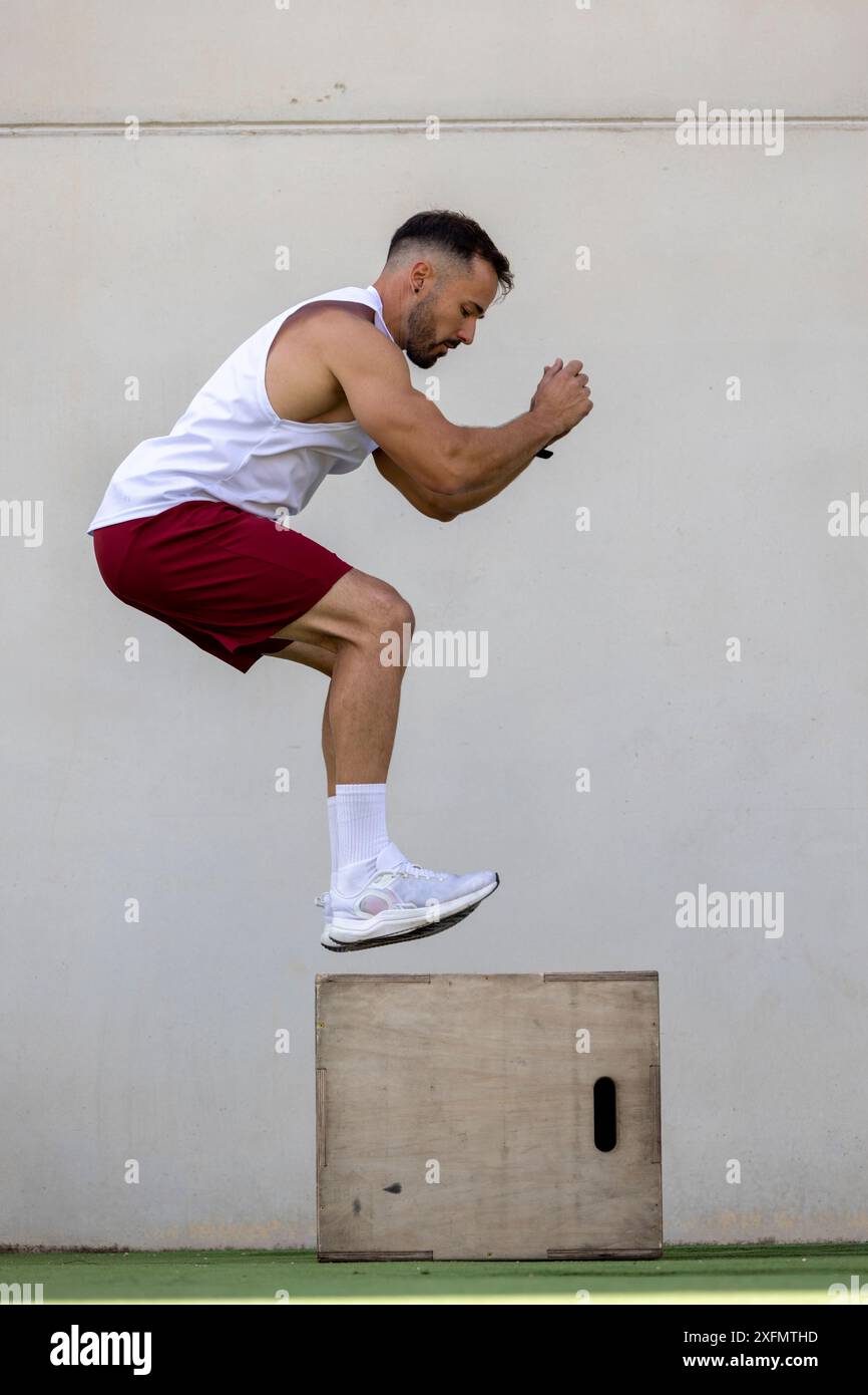 Man doing CrossFit jumping onto a box outdoors Stock Photo - Alamy