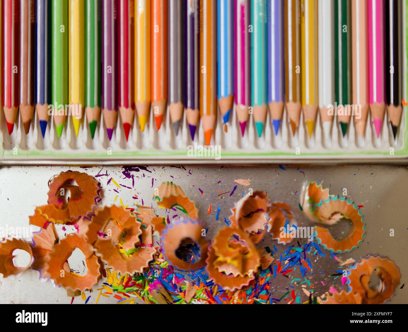 A vibrant collection of colored pencils arranged neatly with shavings ...