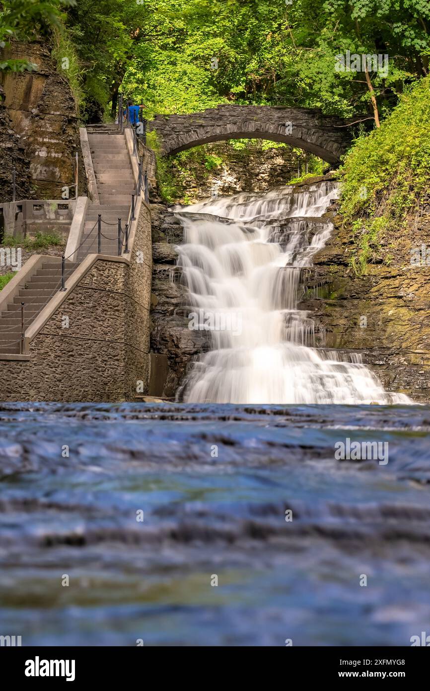 Vertical photo of a waterfall with a trail / concrete stairs ...
