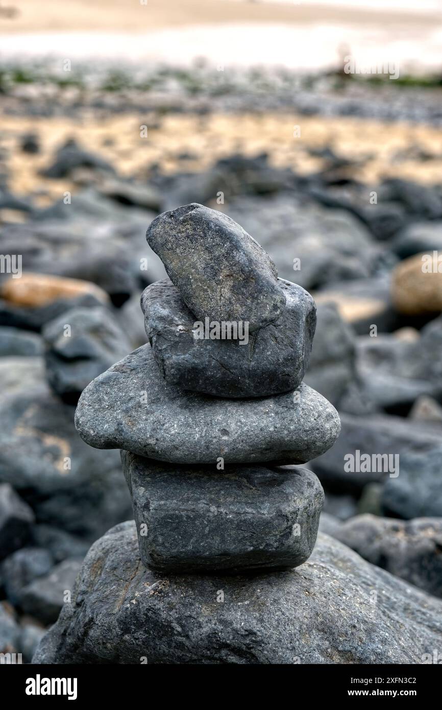 A stack of balancing rocks and stones on the beach in St Ives, Cornwall ...