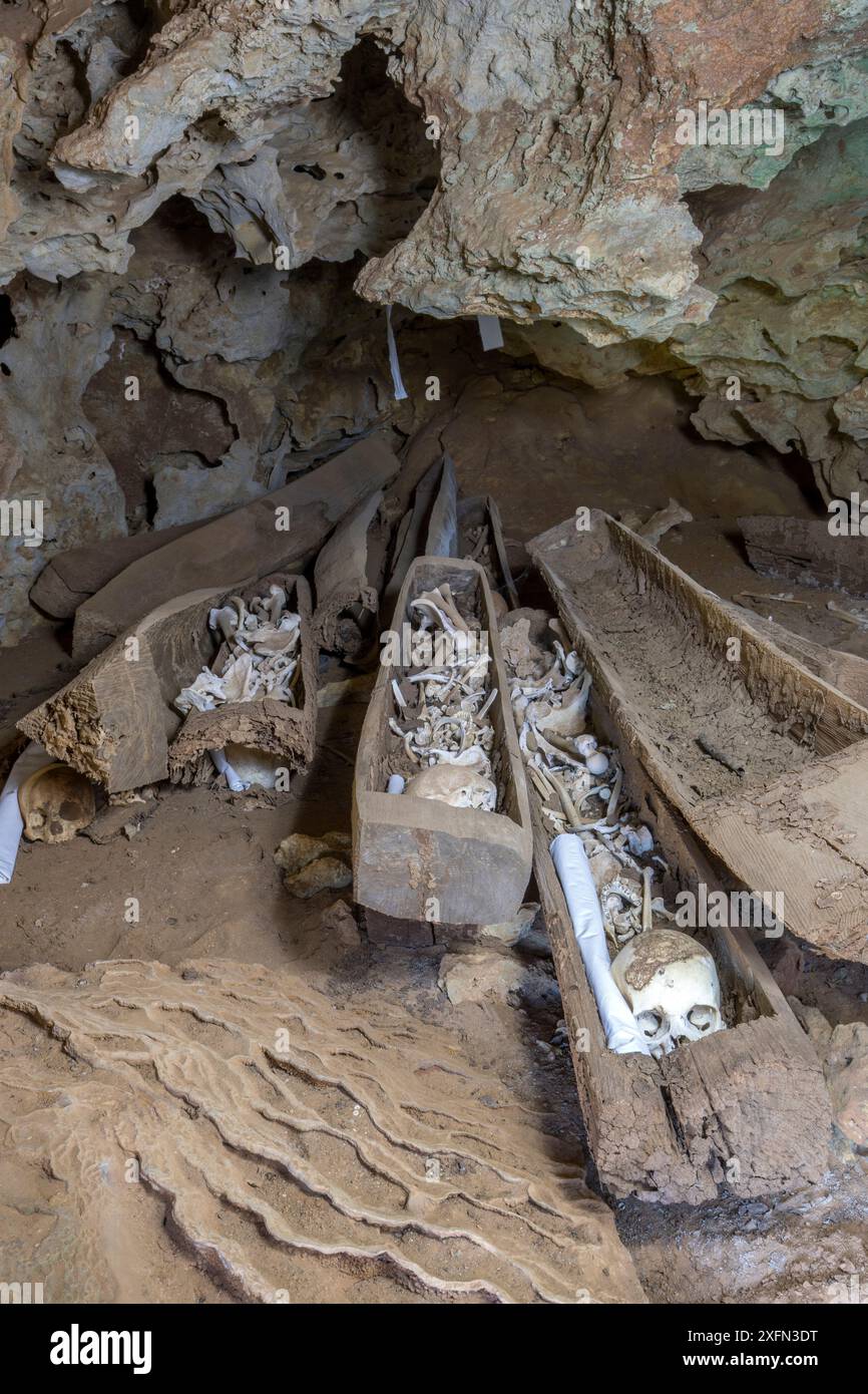 Human skulls and bones in wooden troughs, traditional burial site from ...
