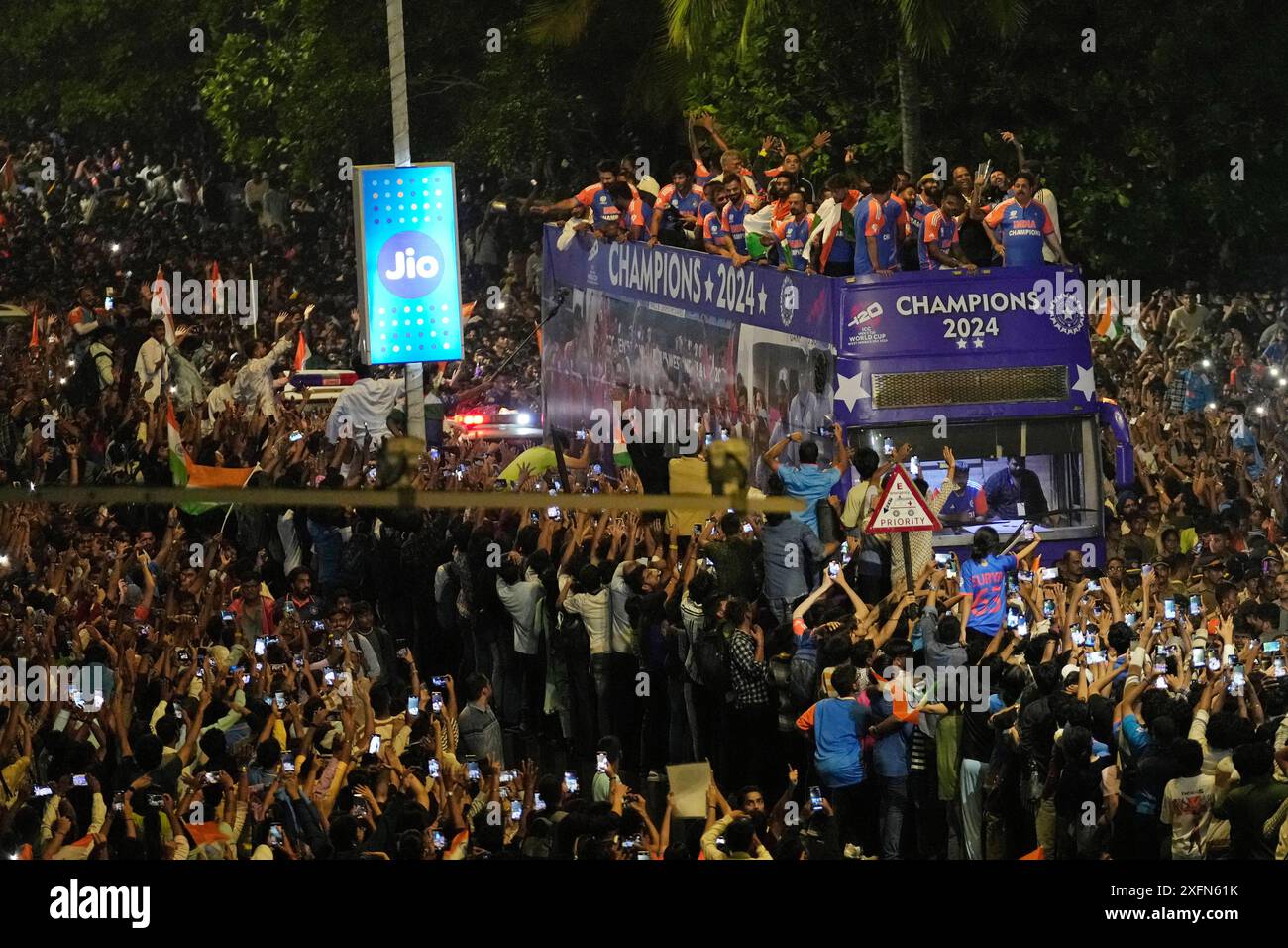 Crowds surround a double-decker bus as the India cricket team takes ...