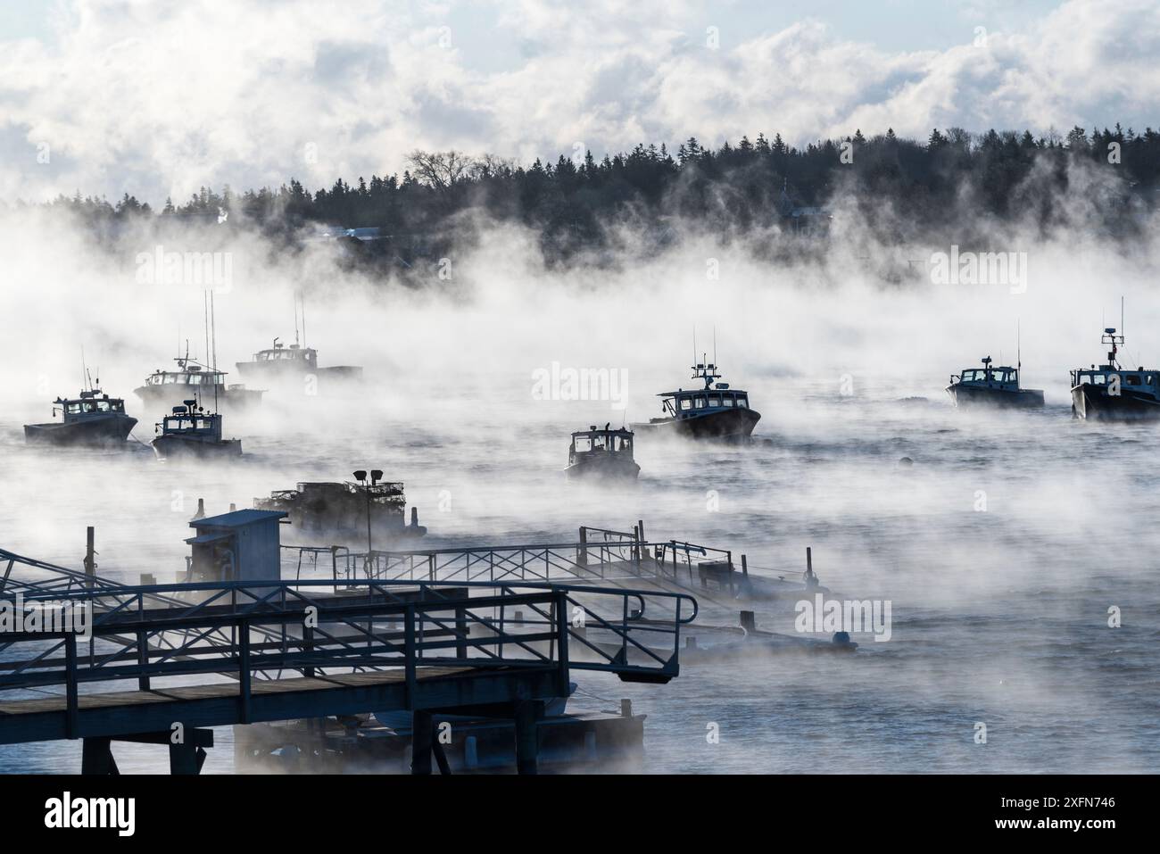 Sea mist rising from the water surface around lobster fishing boats ...