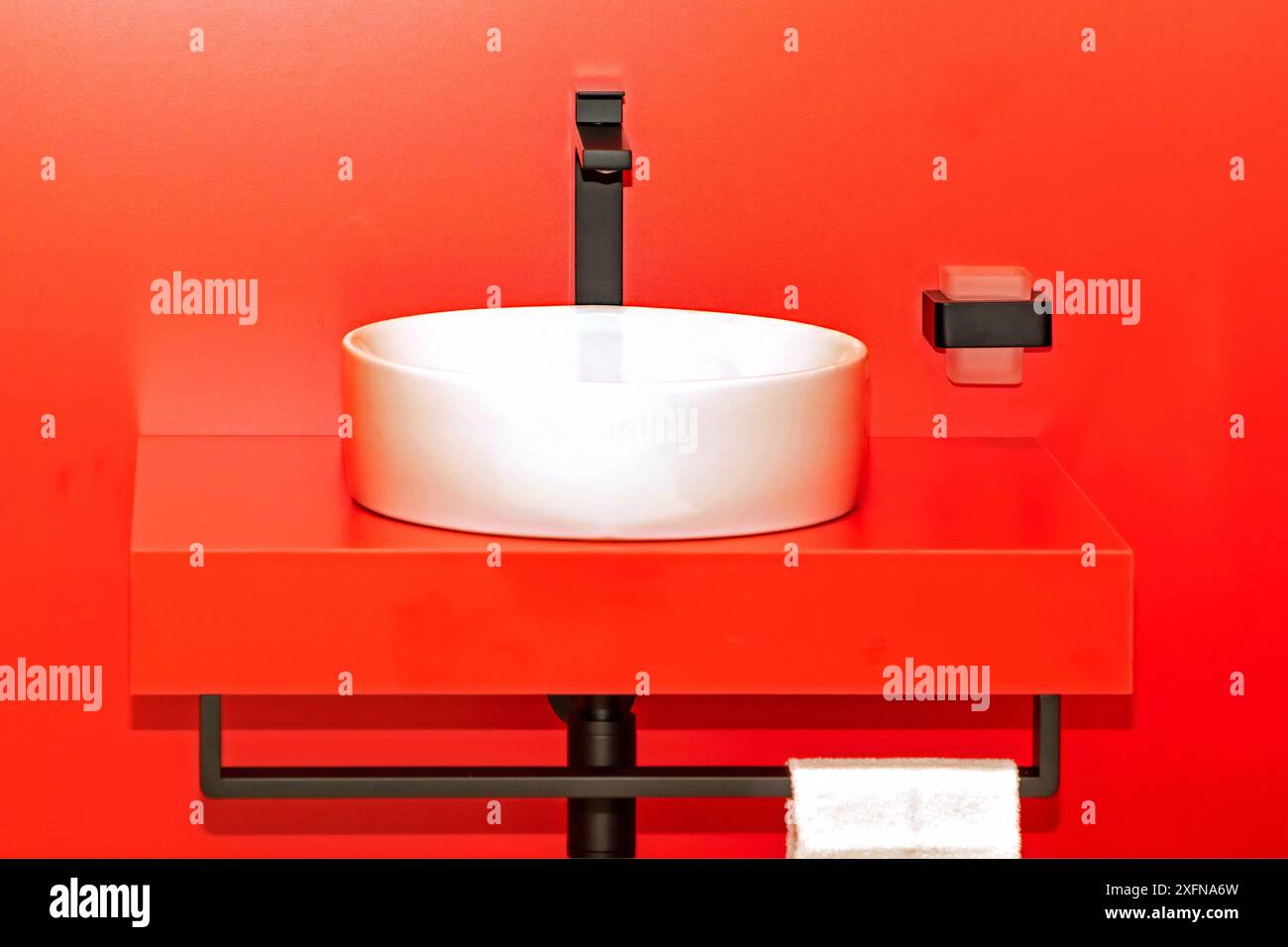 White ceramic sink inside bathroom interior with red tiles background ...