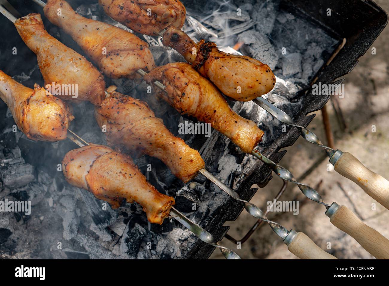 Chicken shanks on skewers on grill, grilling Stock Photo - Alamy