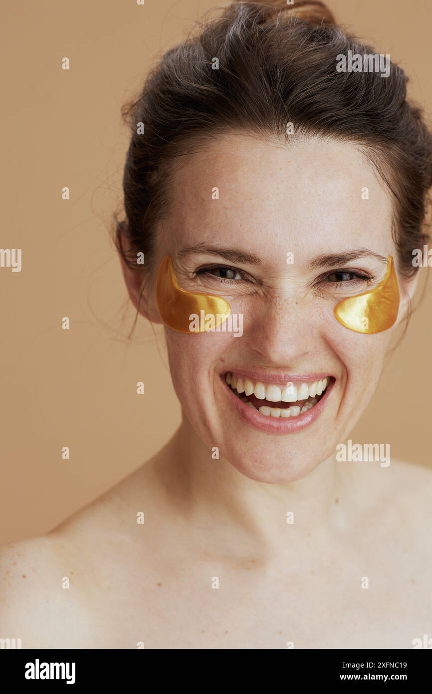 happy young woman with eye patches against beige background Stock Photo ...