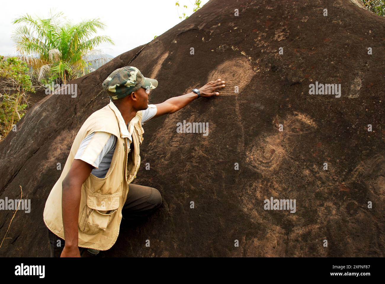 Man with petroglyphs, neolithic rock art. LopÃ© National Park ...