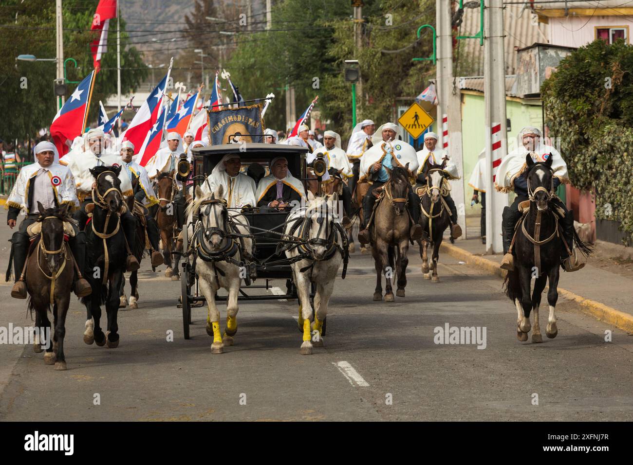 A cardinal in a horse-drawn carriage surrounded by traditionally ...