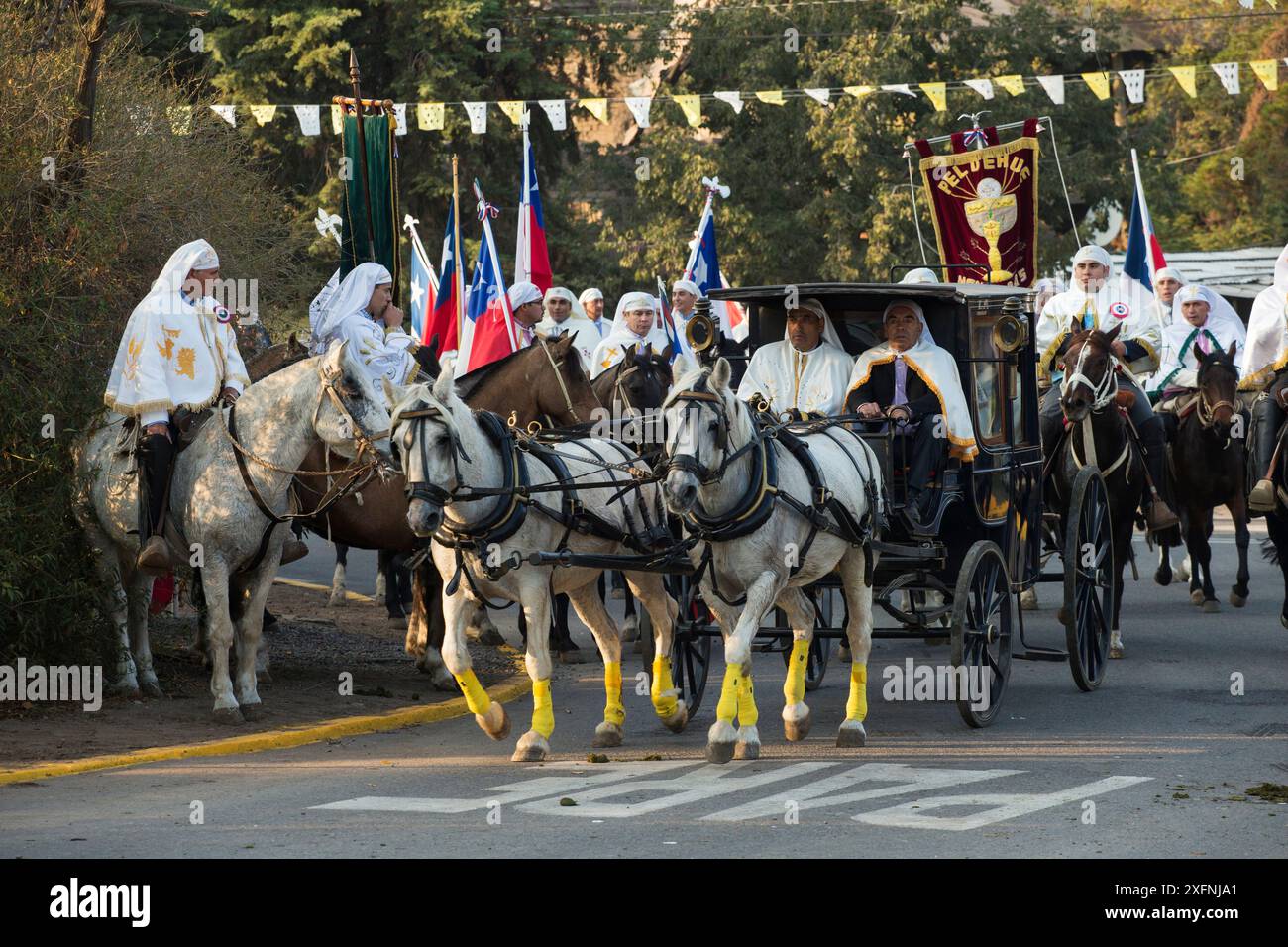 A cardinal in a horse-drawn carriage surrounded by traditionally ...